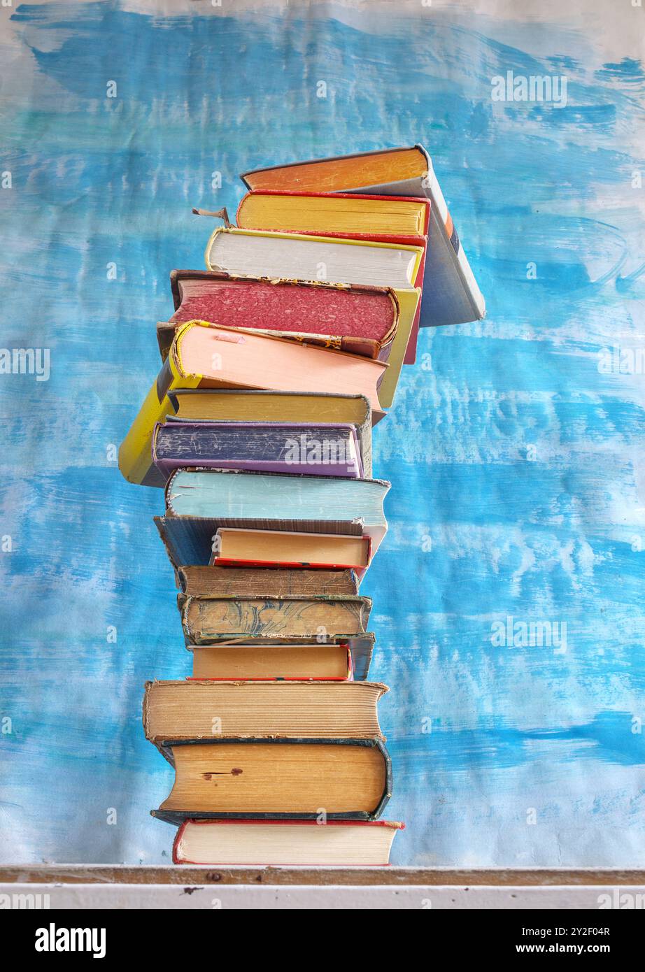 High stack of books with blue grungy background, back to school reading ...