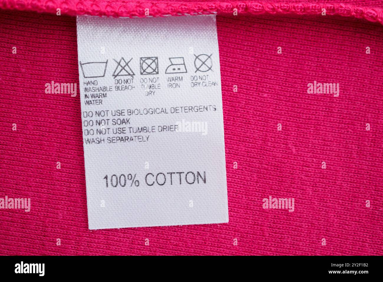 White laundry care washing instructions clothes label on red cotton ...
