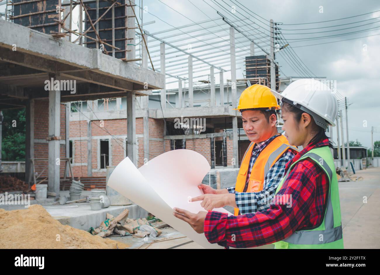 Team engineers checking blueprint and planning project working outdoors building side on a ...