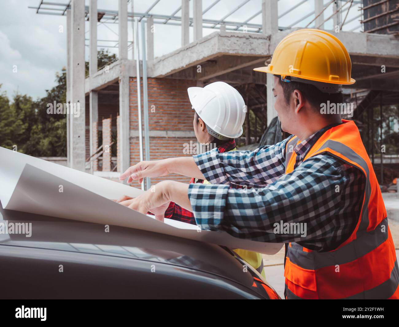 Team engineers checking blueprint and planning project working outdoors building side on a ...