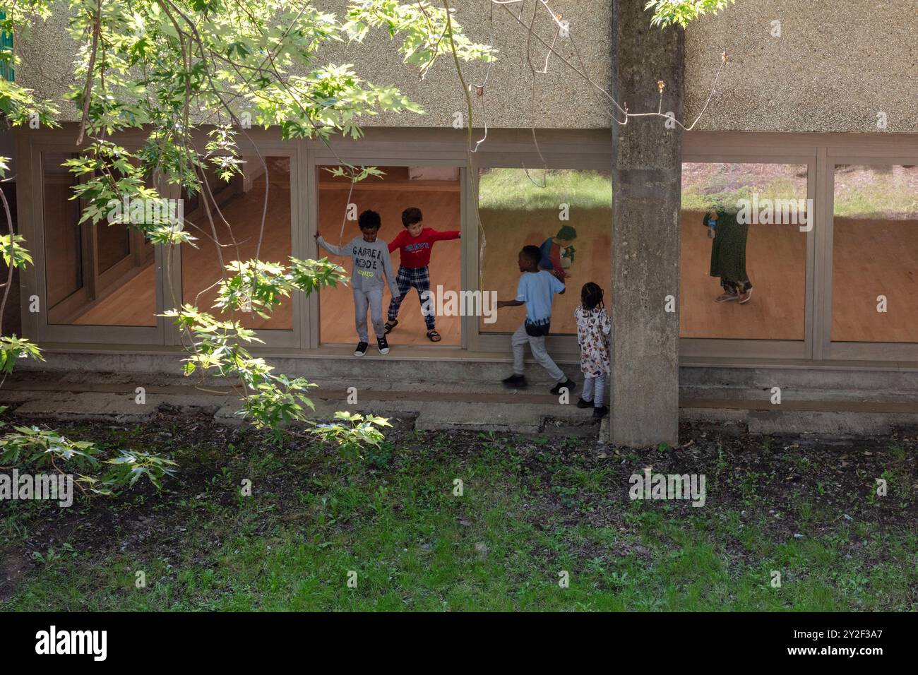 Children playing around the doors of the new centre. Open Havelock, Southall, United Kingdom ...