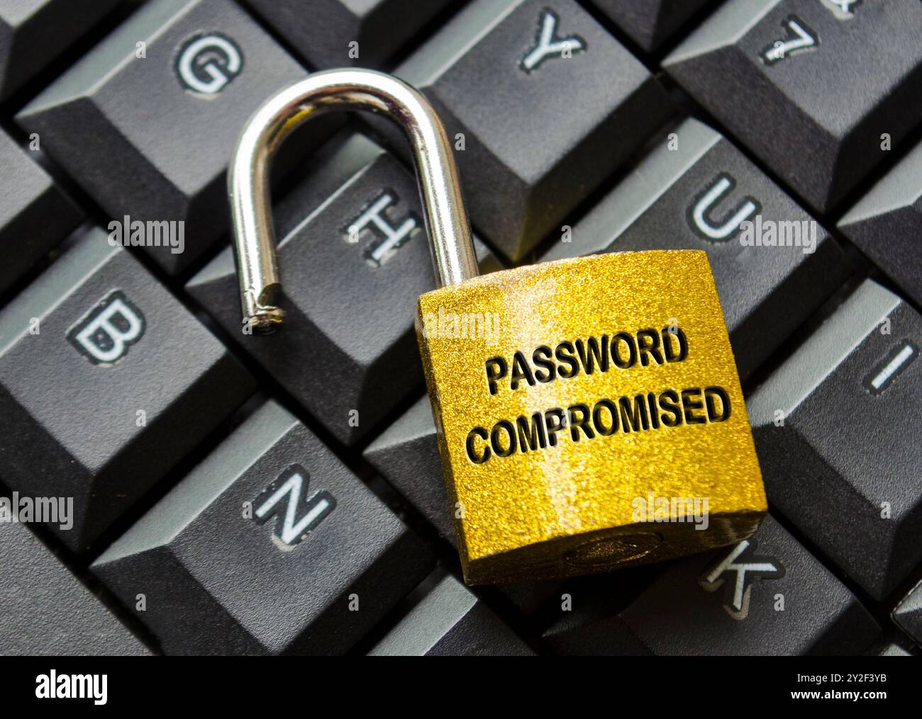 Top view of Password Compromised text engraved on padlock with keyboard ...