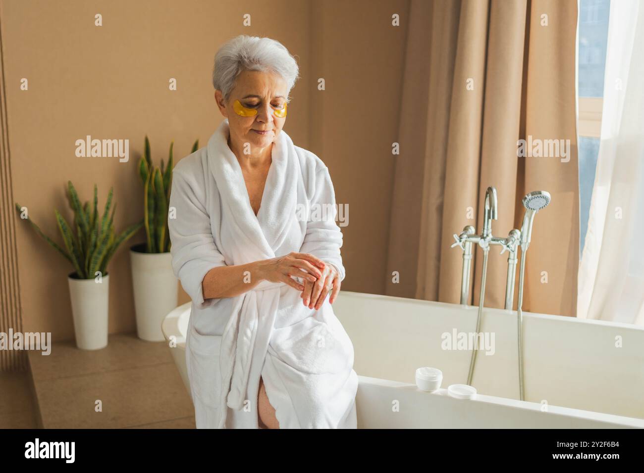Mature woman rubbing lotion on hi-res stock photography and images - Alamy