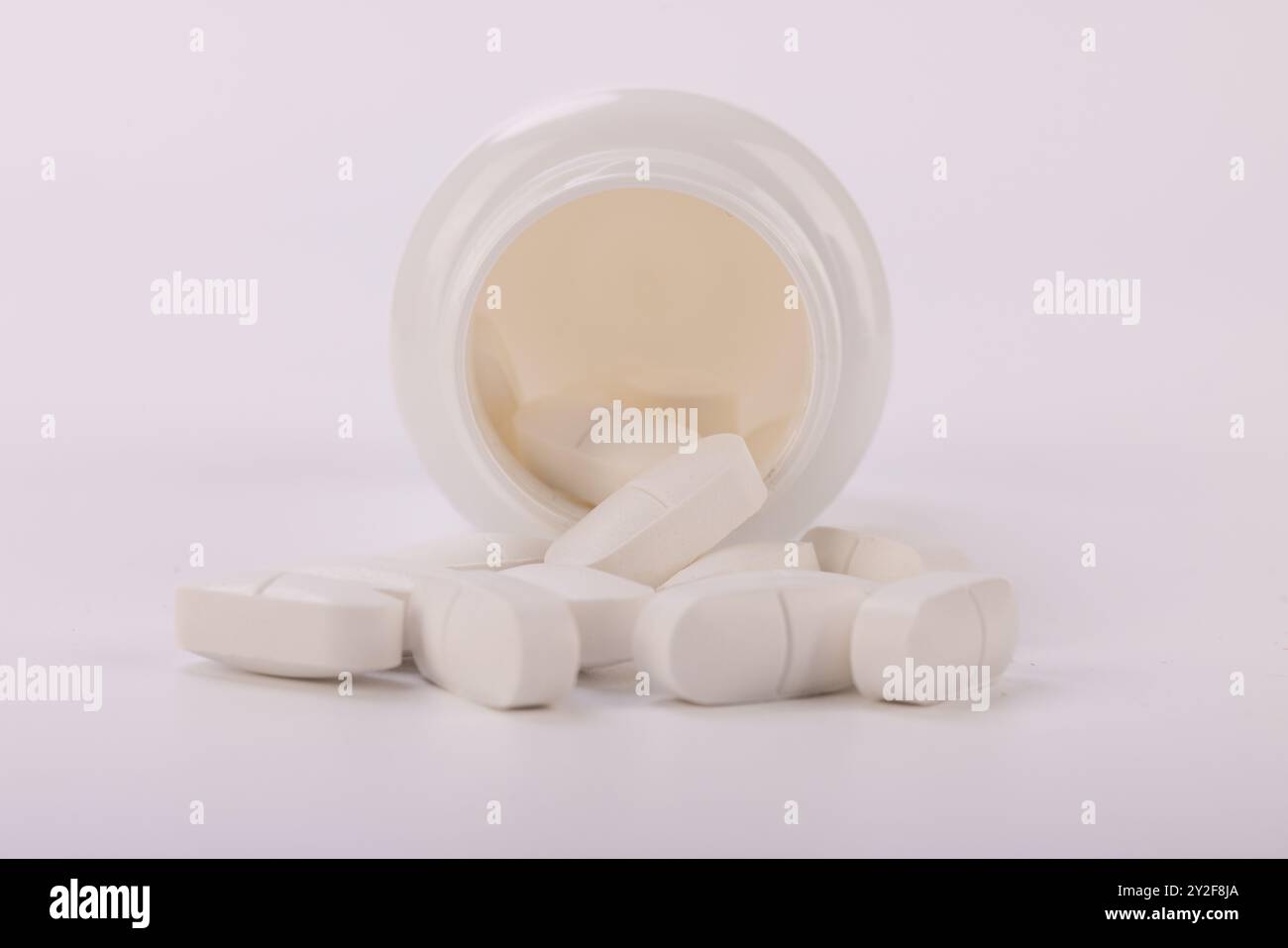 This detailed image showcases a white bottle of pills, illustrating the ...