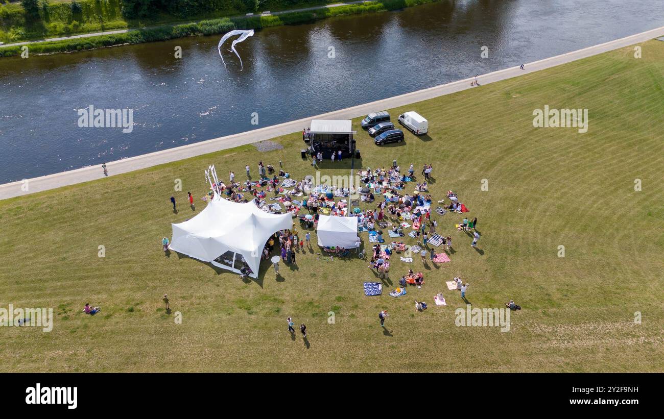 Aerial view of a large outdoor gathering with people sitting on ...