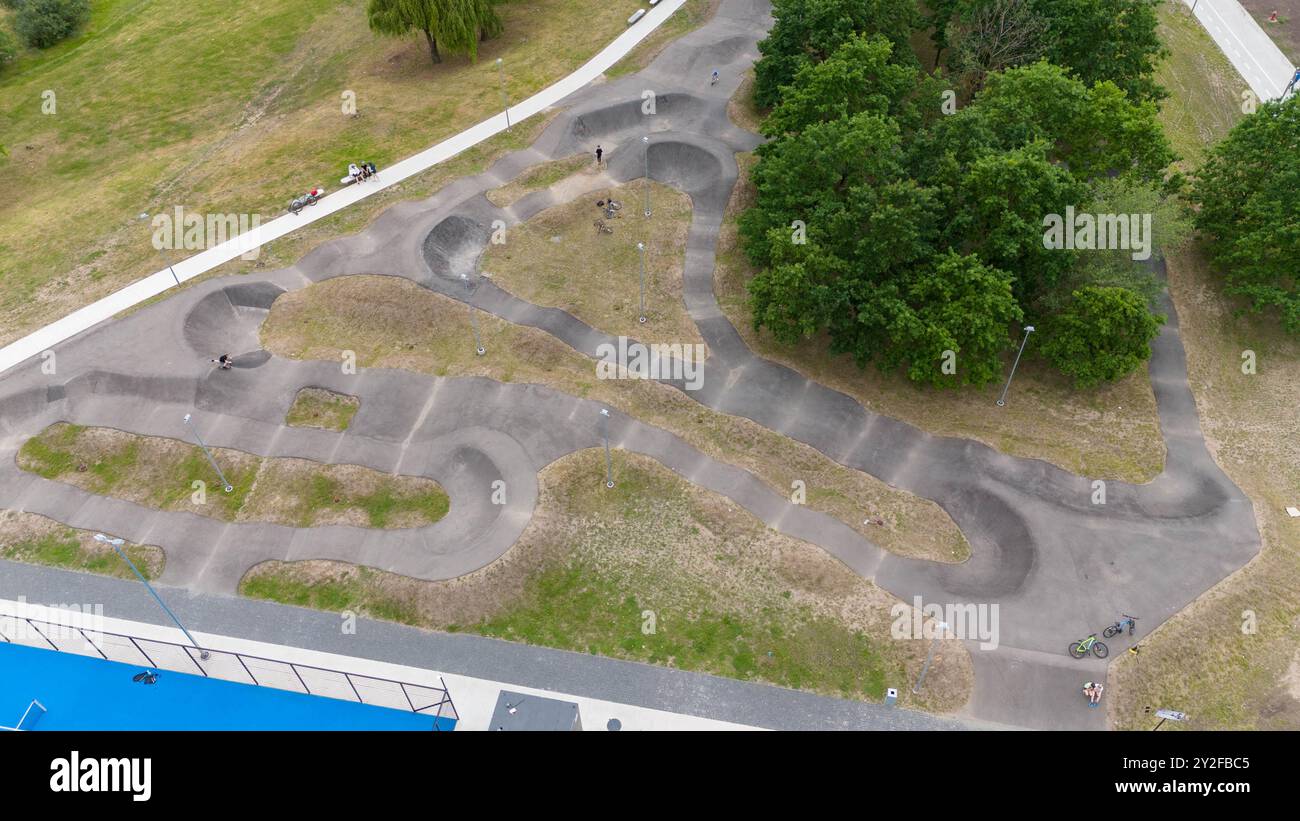 An aerial view of a bike pump track surrounded by greenery. The track ...