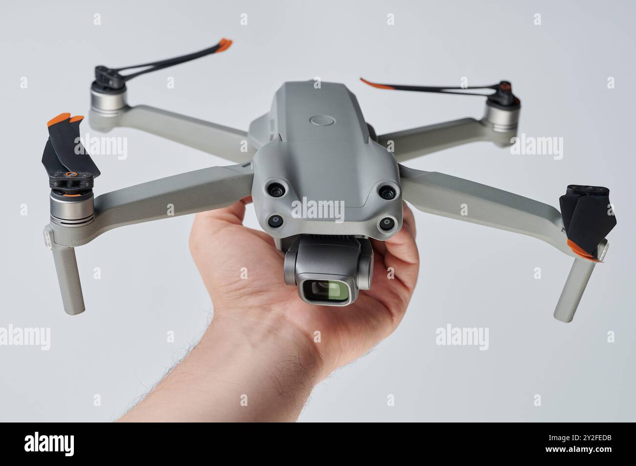 Hand holding unfolded drone close up view isolated on white studio ...