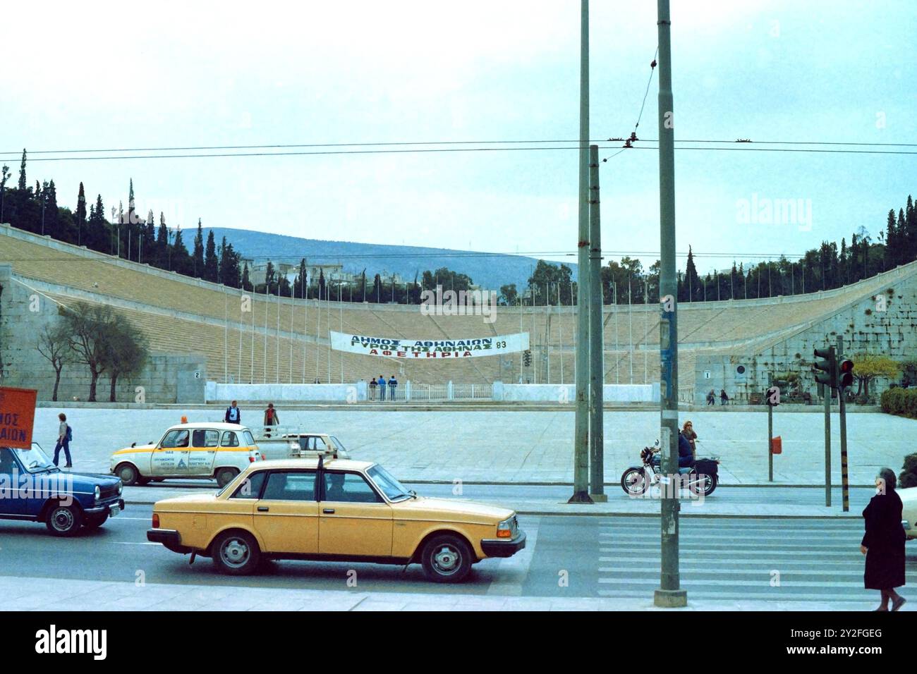 Old 1980's 35mm negative film scan. A volvo car passes the Panathenaic ...