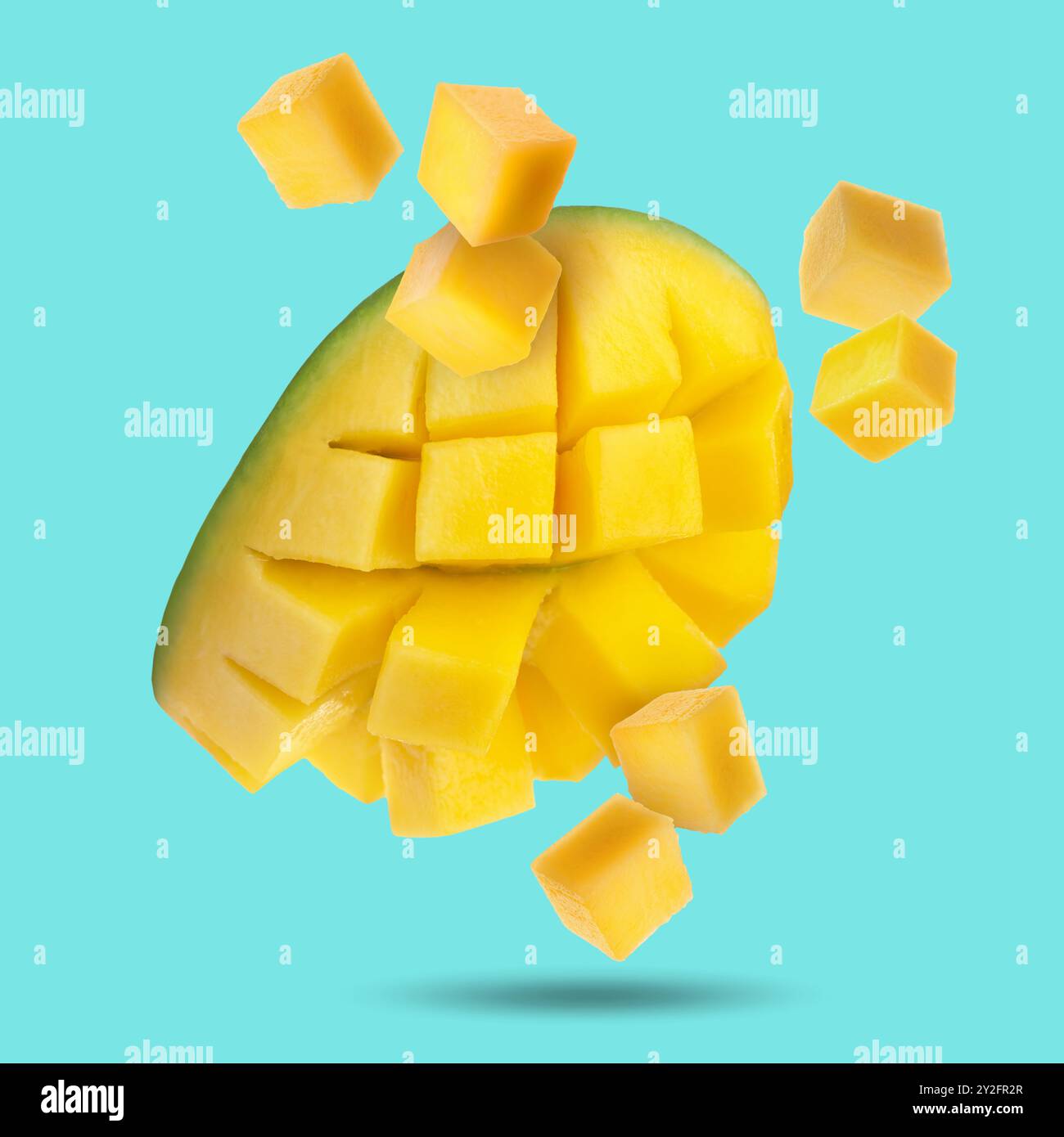 Sweet fresh mango cut in cubes falling on turquoise background Stock ...