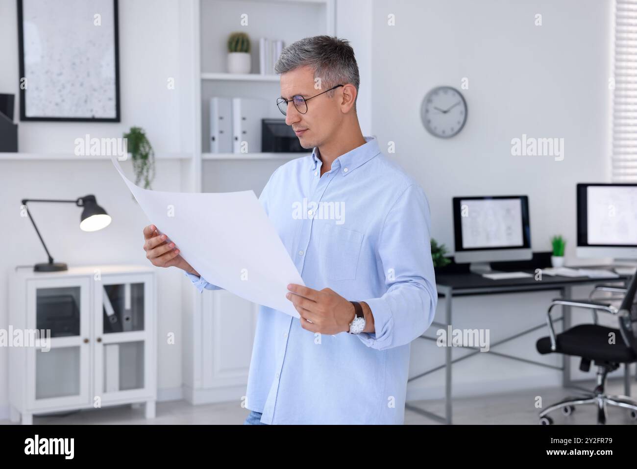 Architect holding paper sheet with engineering drawing in office Stock ...