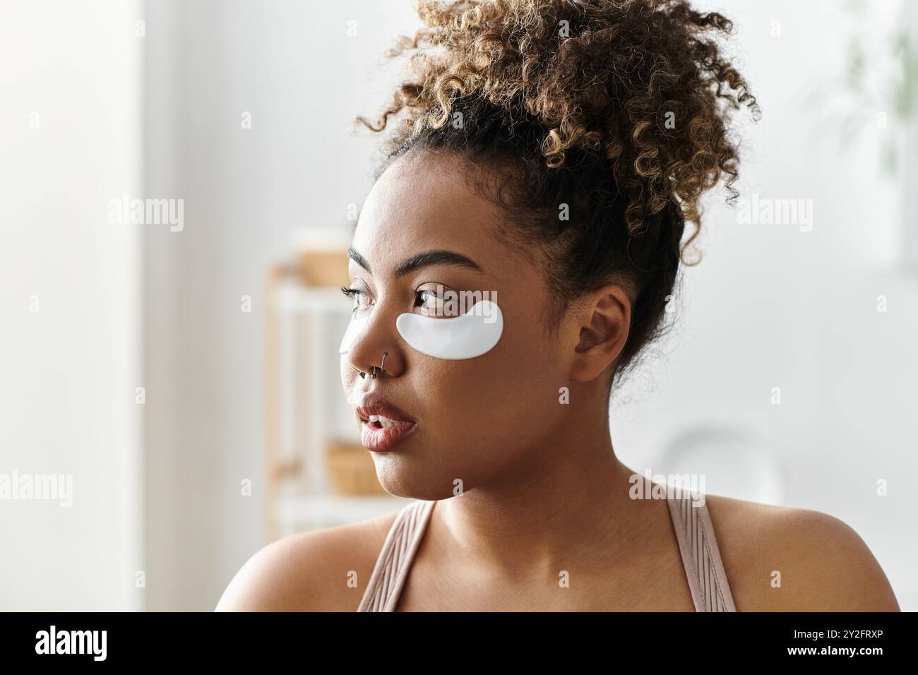 A woman relaxes at home with under eye masks, embracing a peaceful self ...