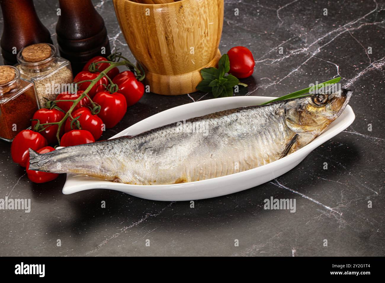 Whole raw salted herring fish in the plate Stock Photo - Alamy