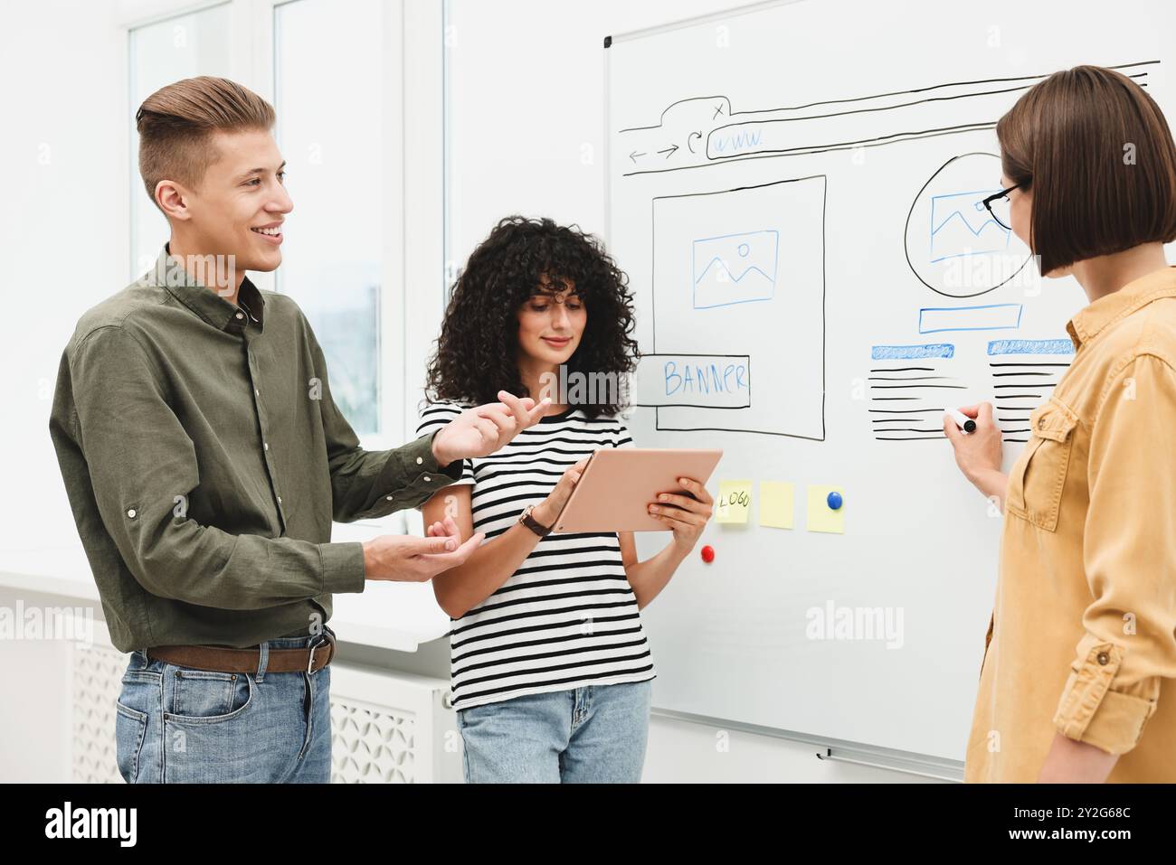 Developing UI design. People drawing website wireframe on whiteboard ...