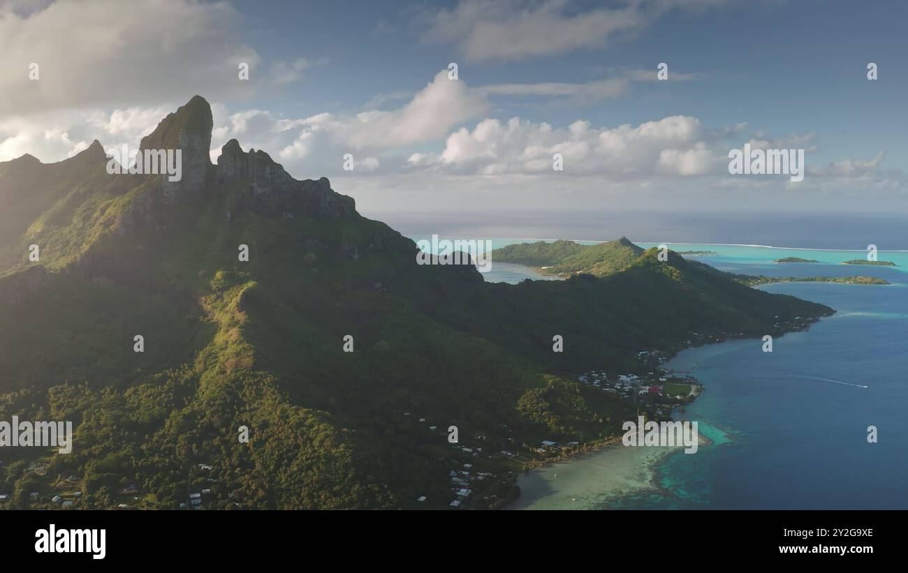 Golden sunlight over iconic mountain peak and turquoise lagoons of Bora ...
