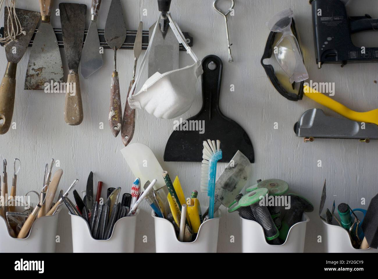 Different tools on the wall in a studio: painter knives, ceramics tools ...