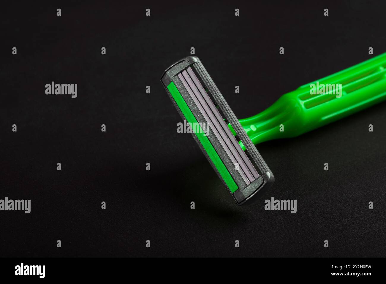 Disposable plastic razor on a black background. Close-up. Skin care ...