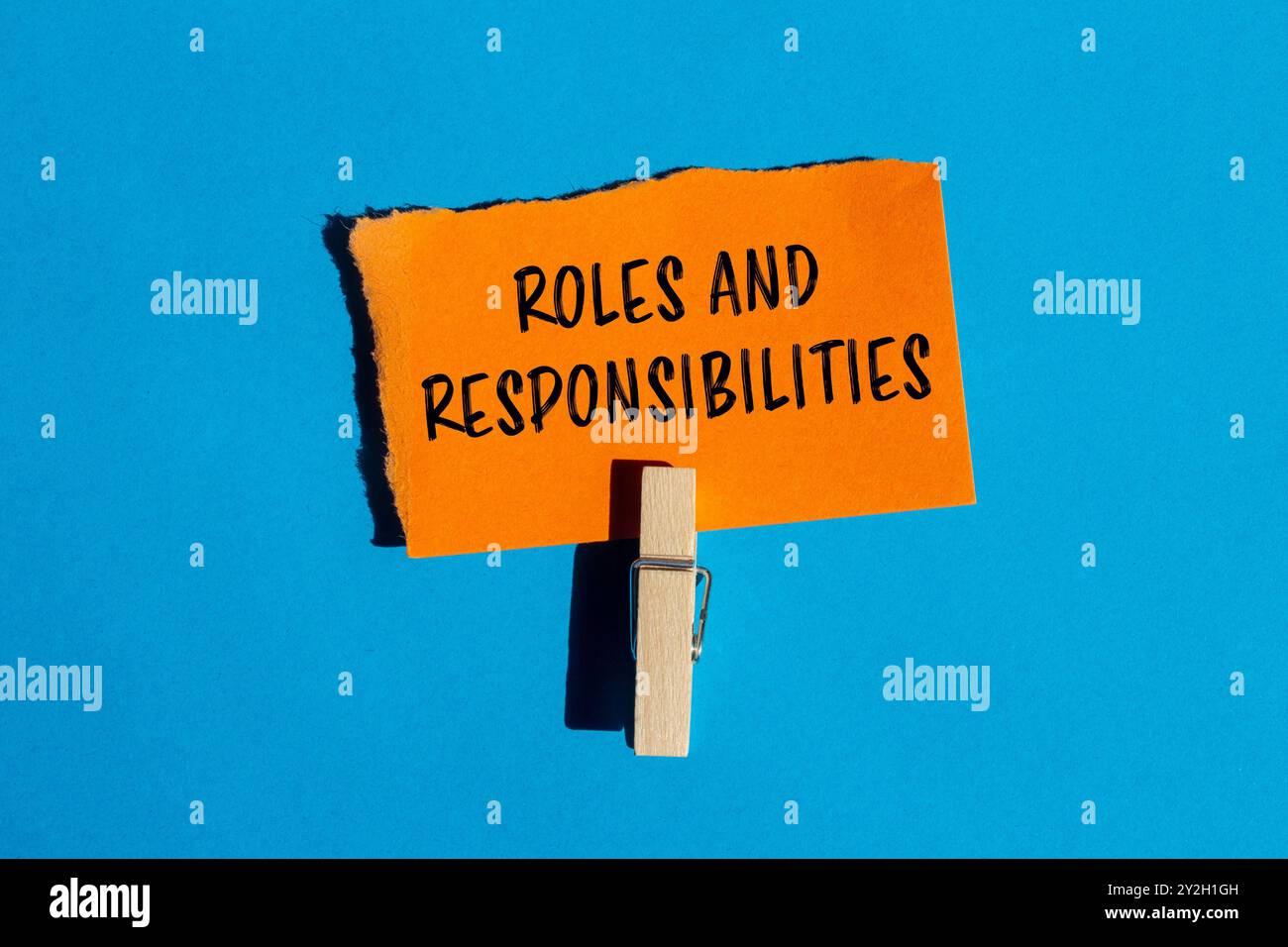 Roles and responsibilities message written on ripped torn orange paper ...