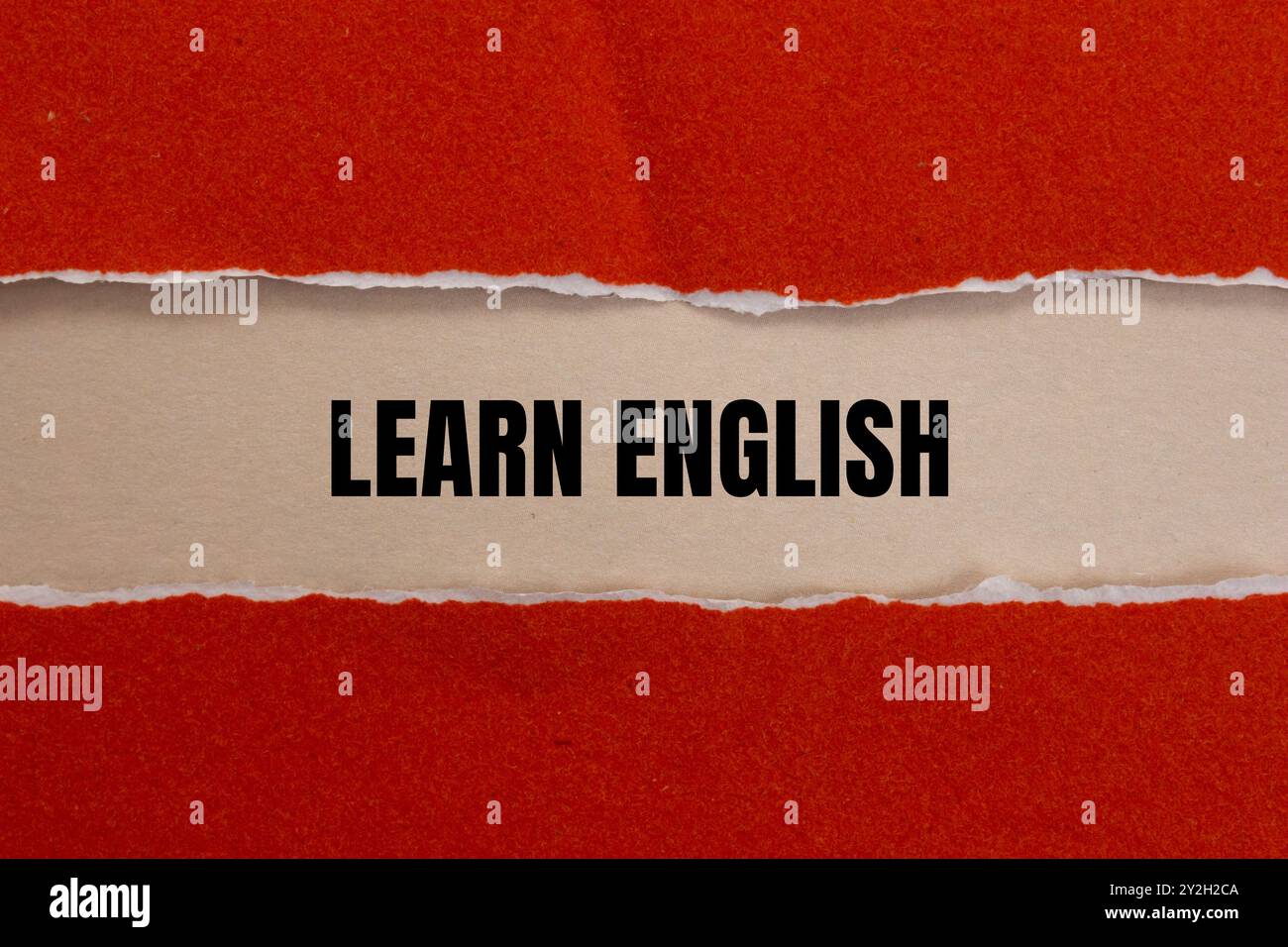 Learn english message written on ripped red torn paper with beige background. Conceptual learn ...