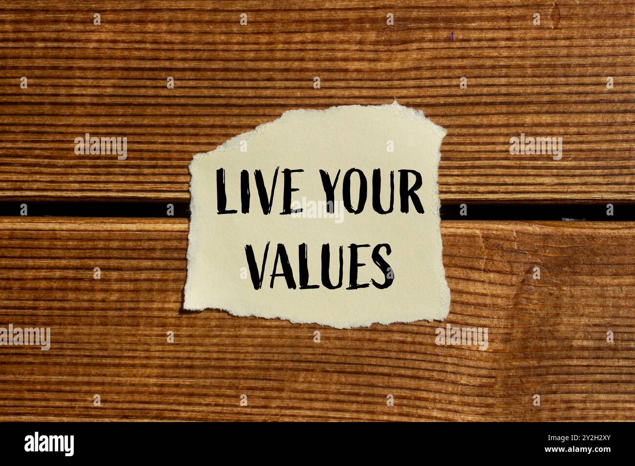 Live your values message written on ripped torn paper with wooden ...