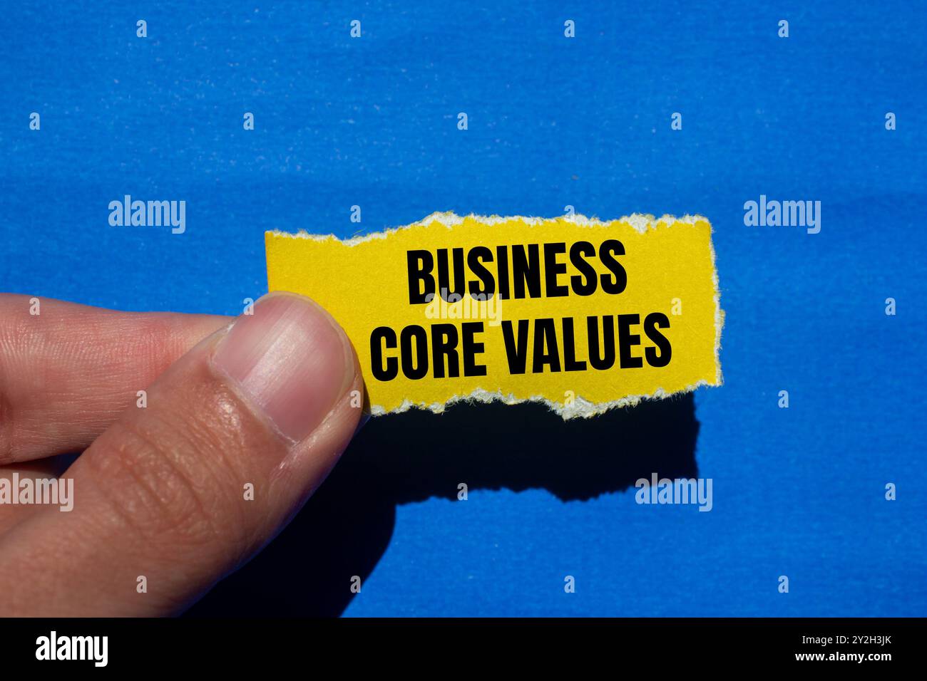 Business core values message written on ripped torn yellow paper with ...