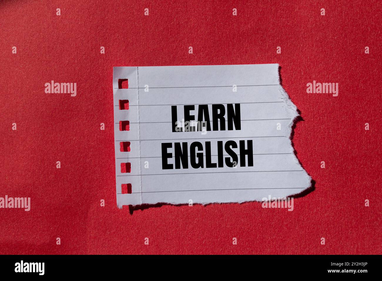 Learn english message written on ripped torn paper with red background. Conceptual learn english ...