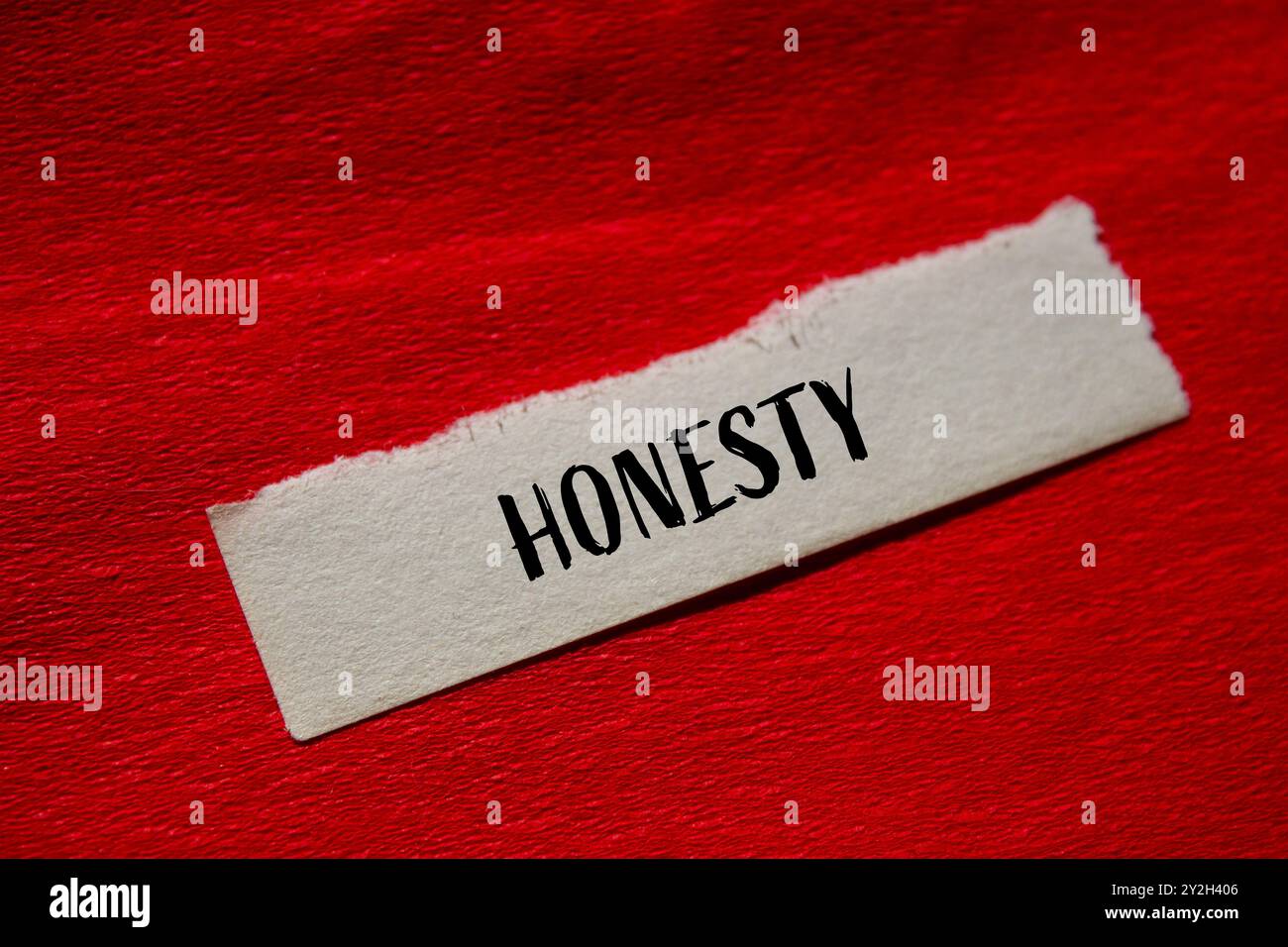 Honesty message written on torn paper with red background. Conceptual ...
