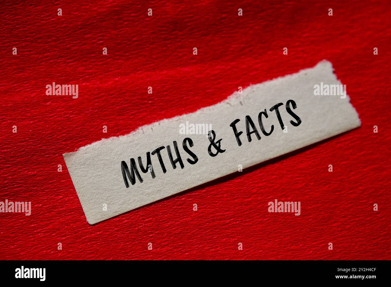 Myths and facts message written on torn paper with red background ...