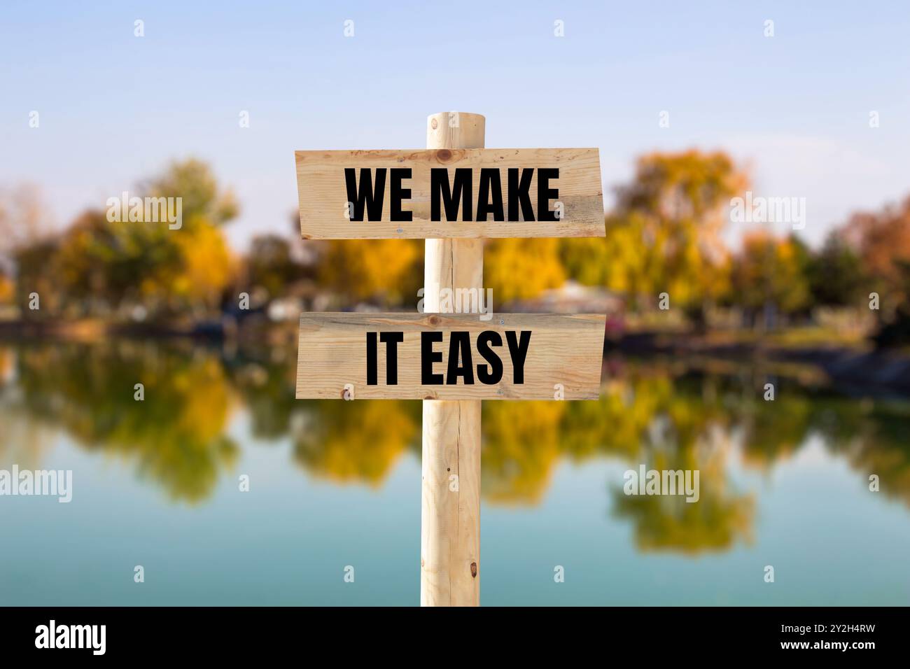 We make it easy message written on wooden sign with blurry nature ...