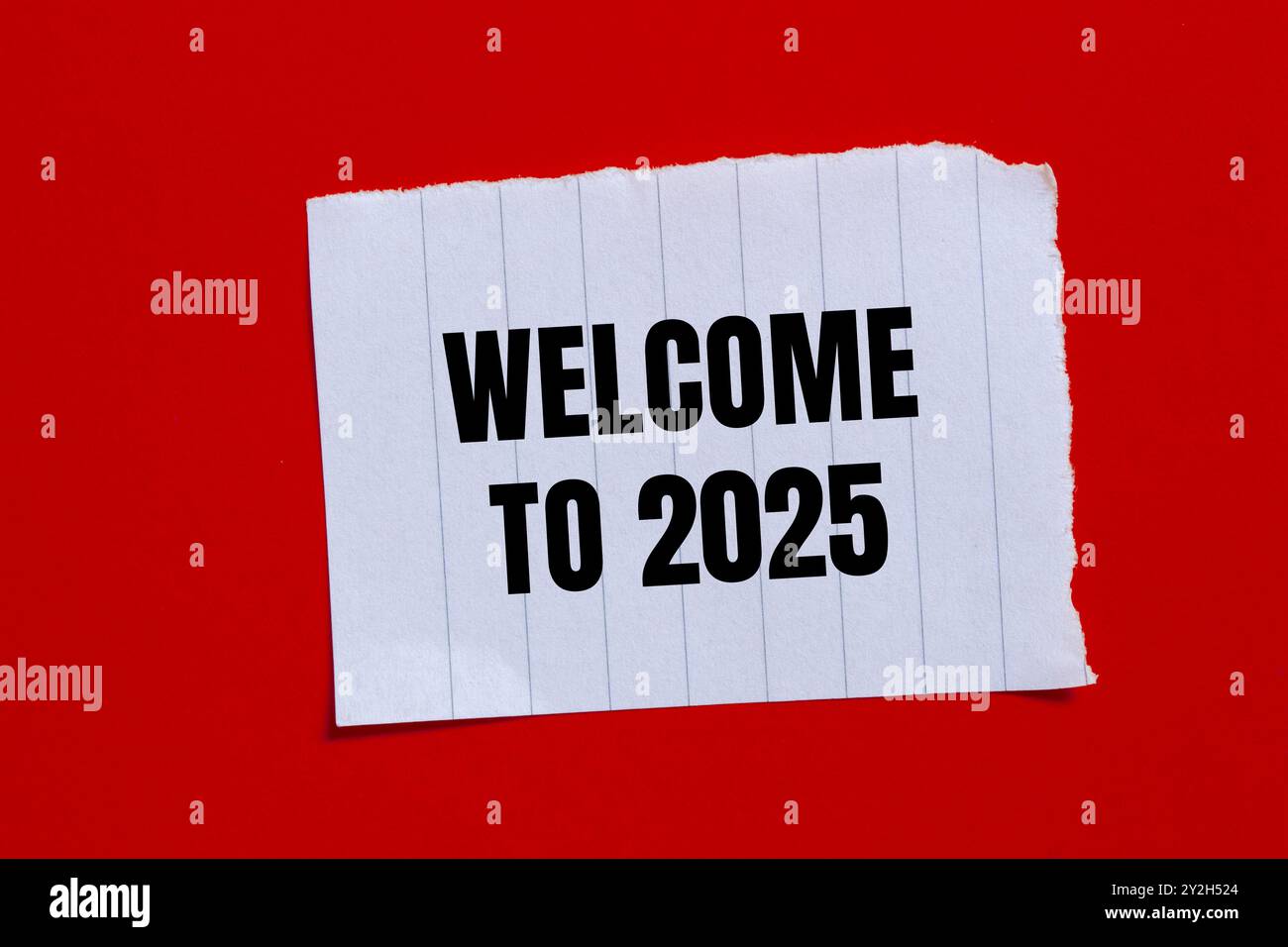 Welcome to 2025 message written on ripped torn paper piece with red background. Conceptual ...