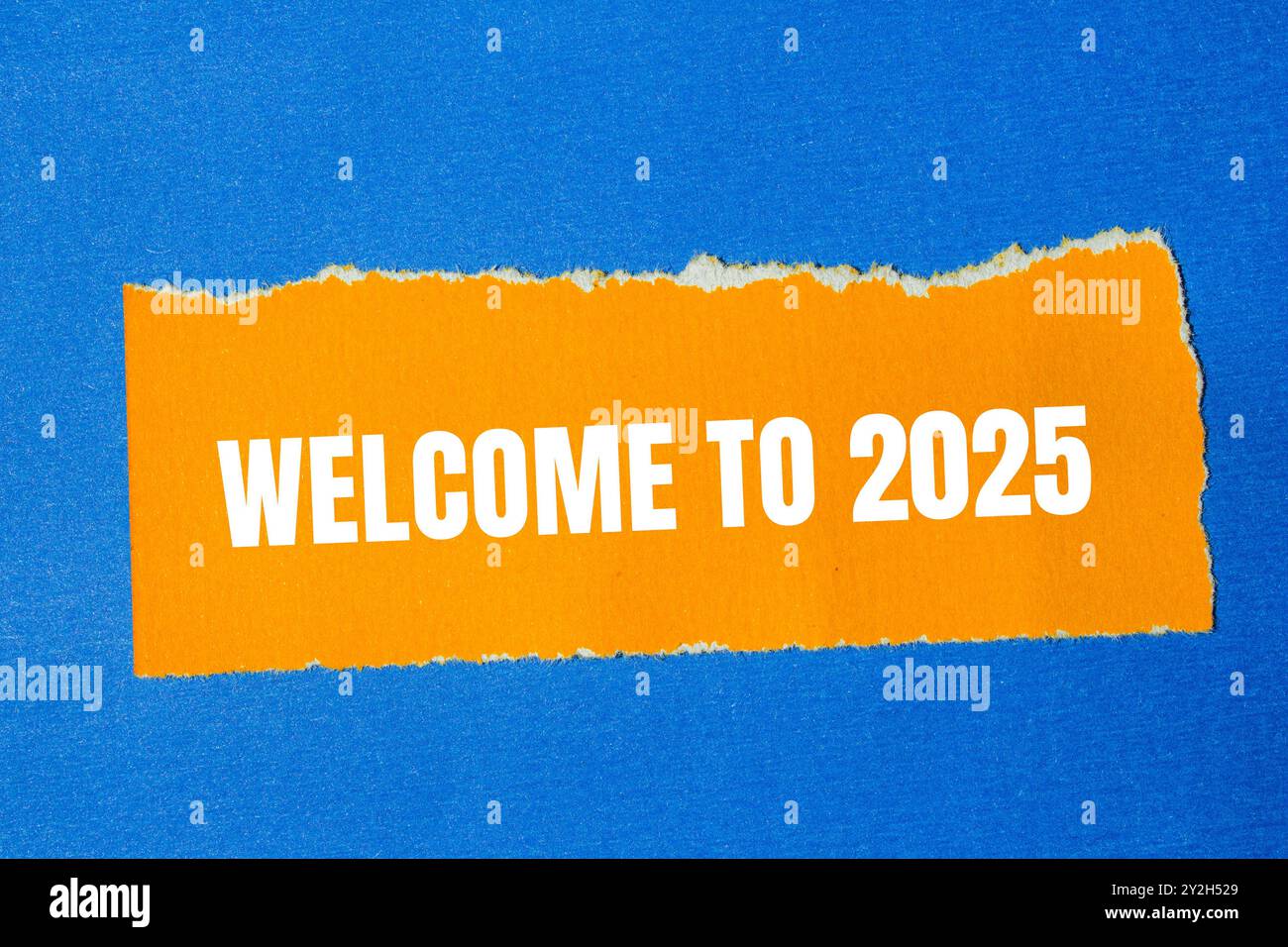 Welcome to 2025 message written on ripped torn orange paper with blue background. Conceptual ...