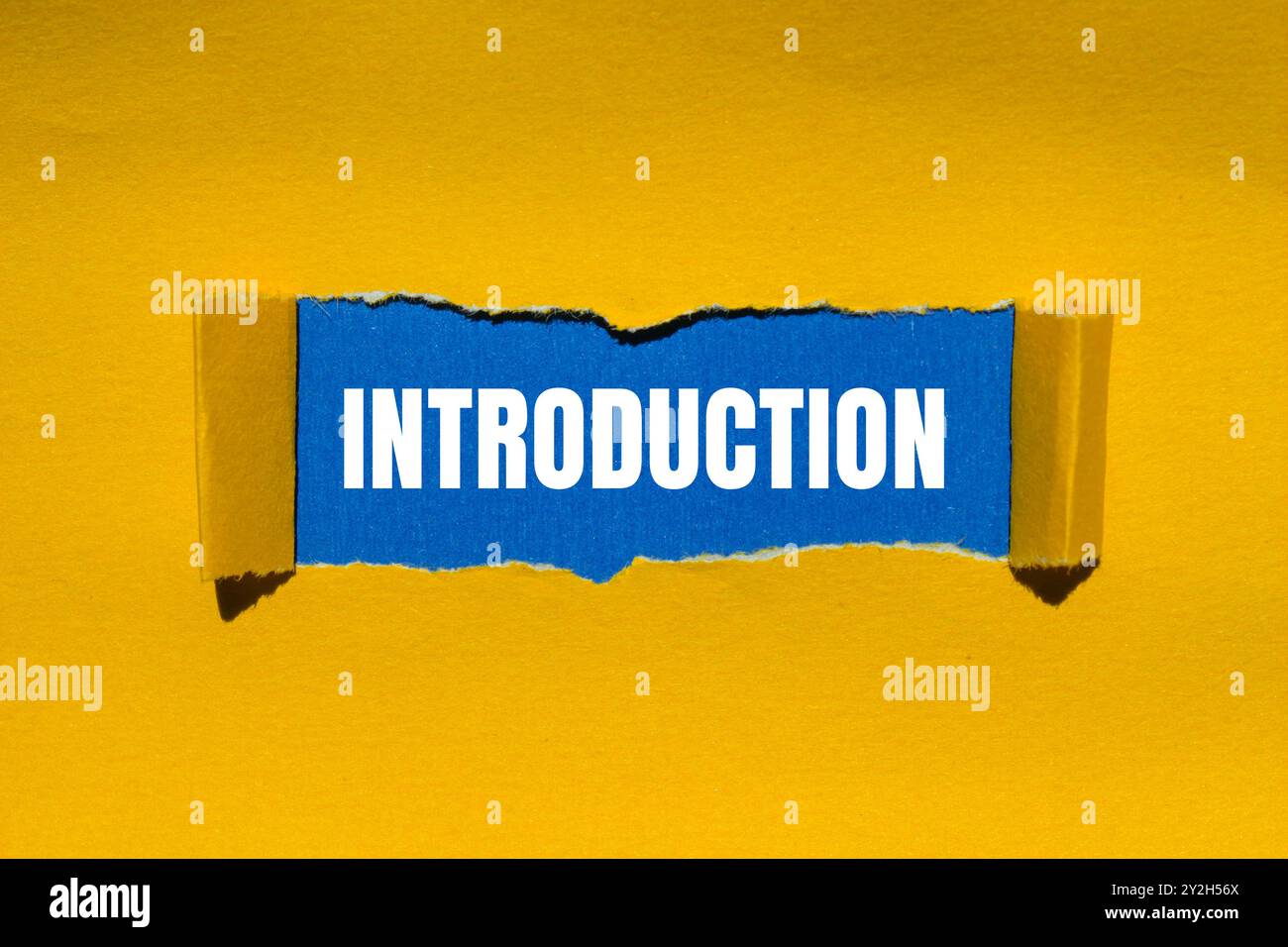 Introduction message written on ripped torn yellow paper with blue ...