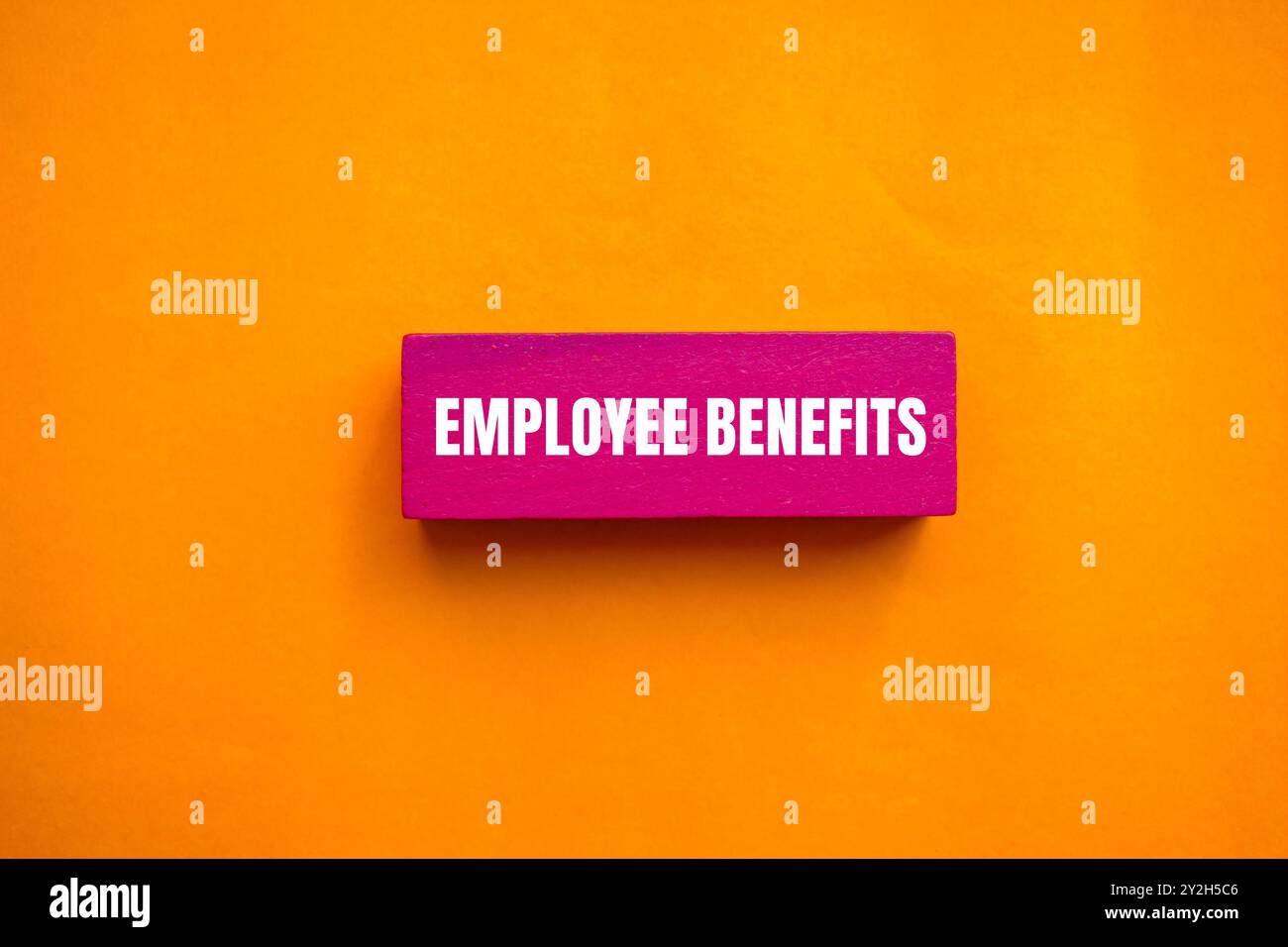 Employee benefits message written on pink wooden block with orange ...