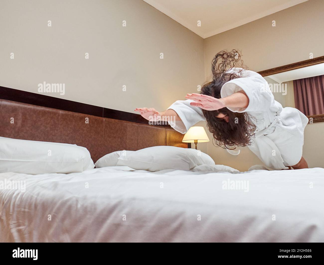 Woman throwing himself into bed Stock Photo - Alamy