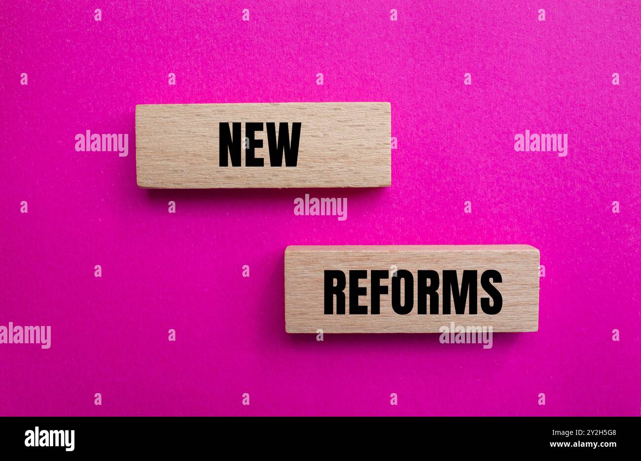 New reforms message written on wooden blocks with pink background ...