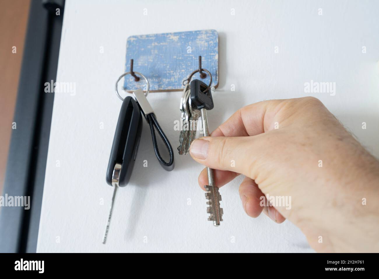 a male hand taking a bunch of keys hanging on the wall Stock Photo - Alamy