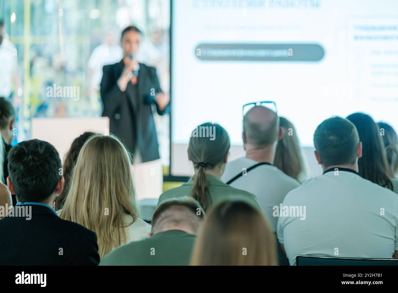 Business professional giving presentation to engaged audience in a ...