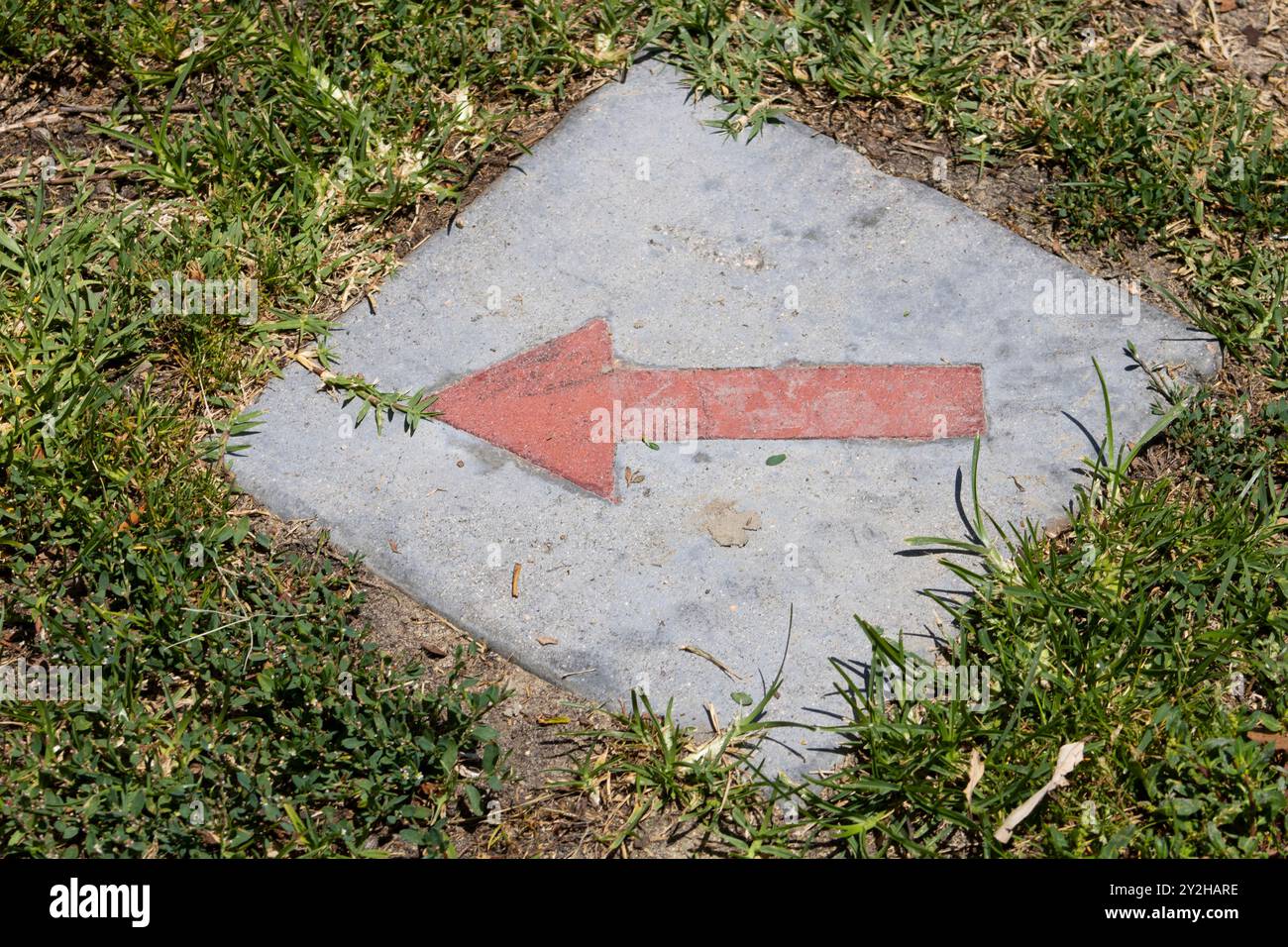stone with red arrow pointing left directions Stock Photo - Alamy