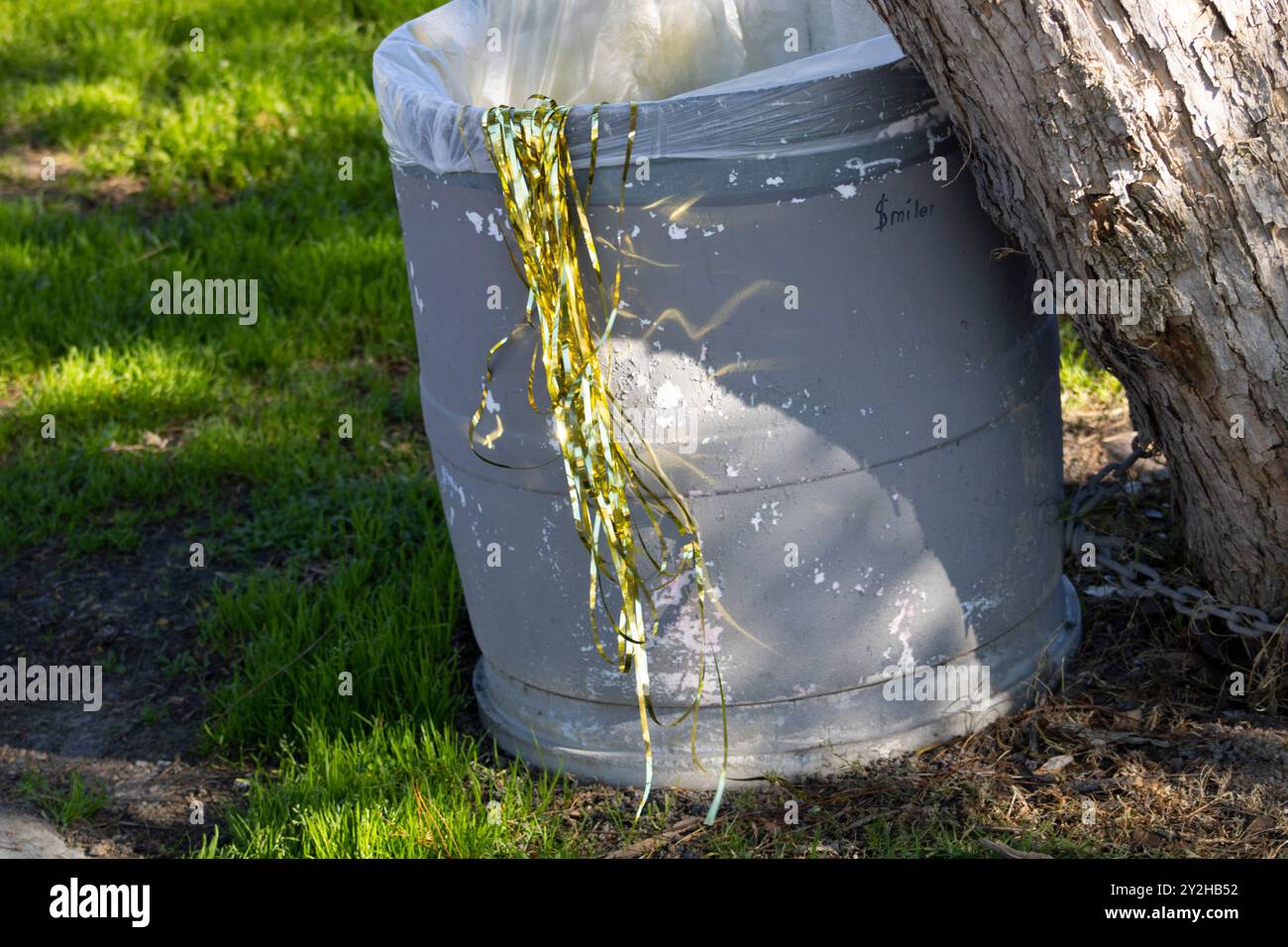 gold celebratory party streamers thrown away in outdoor trash can Stock ...