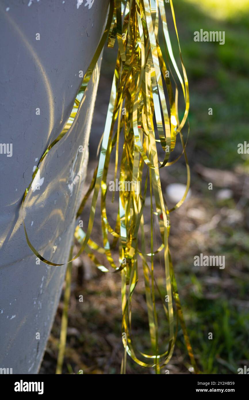 gold celebratory party streamers thrown away in outdoor trash can Stock ...