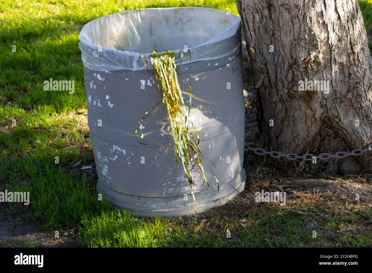 gold celebratory party streamers thrown away in outdoor trash can Stock ...