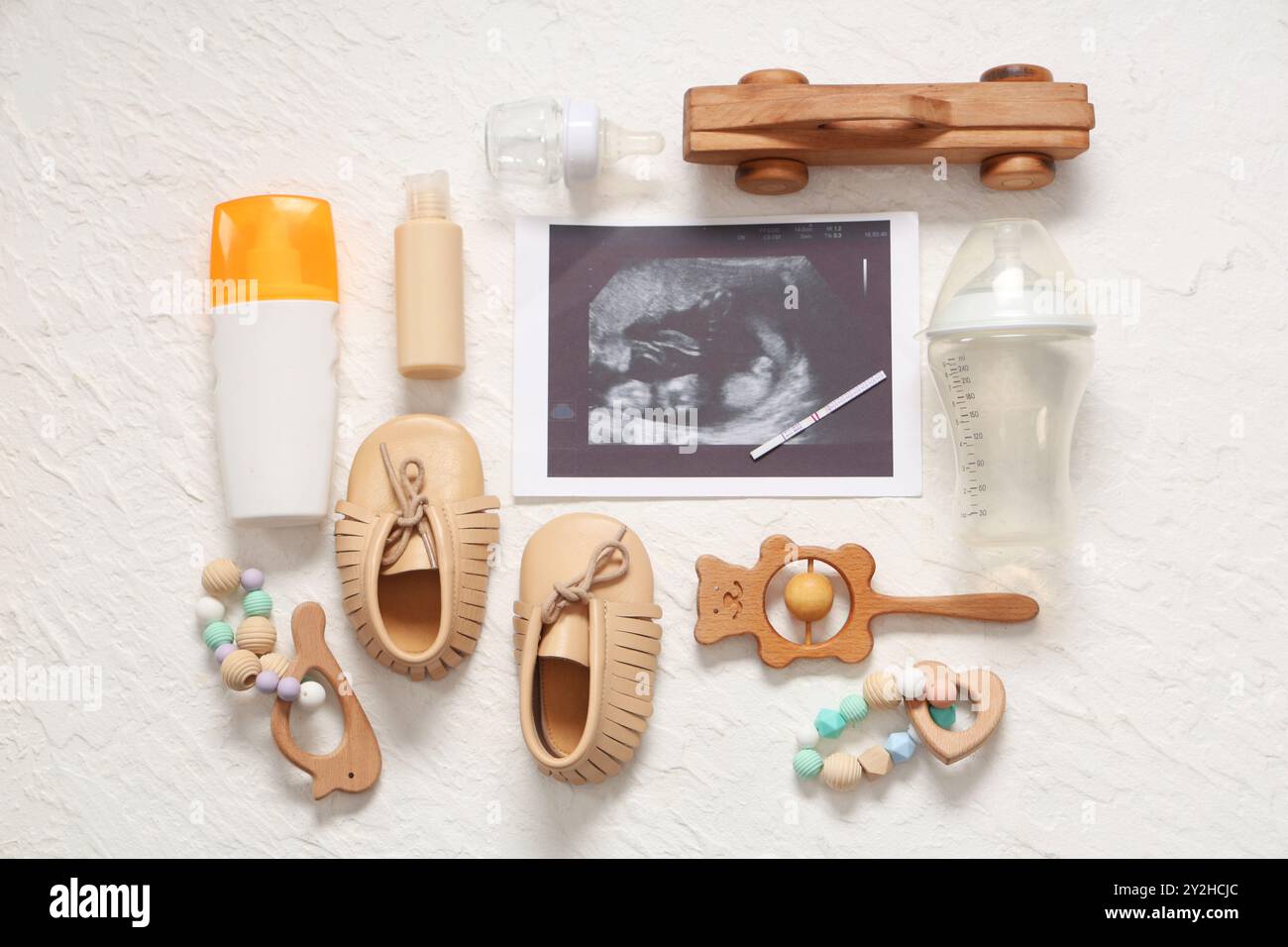 Composition with baby shoes, sonogram image, pregnancy test and toys on ...