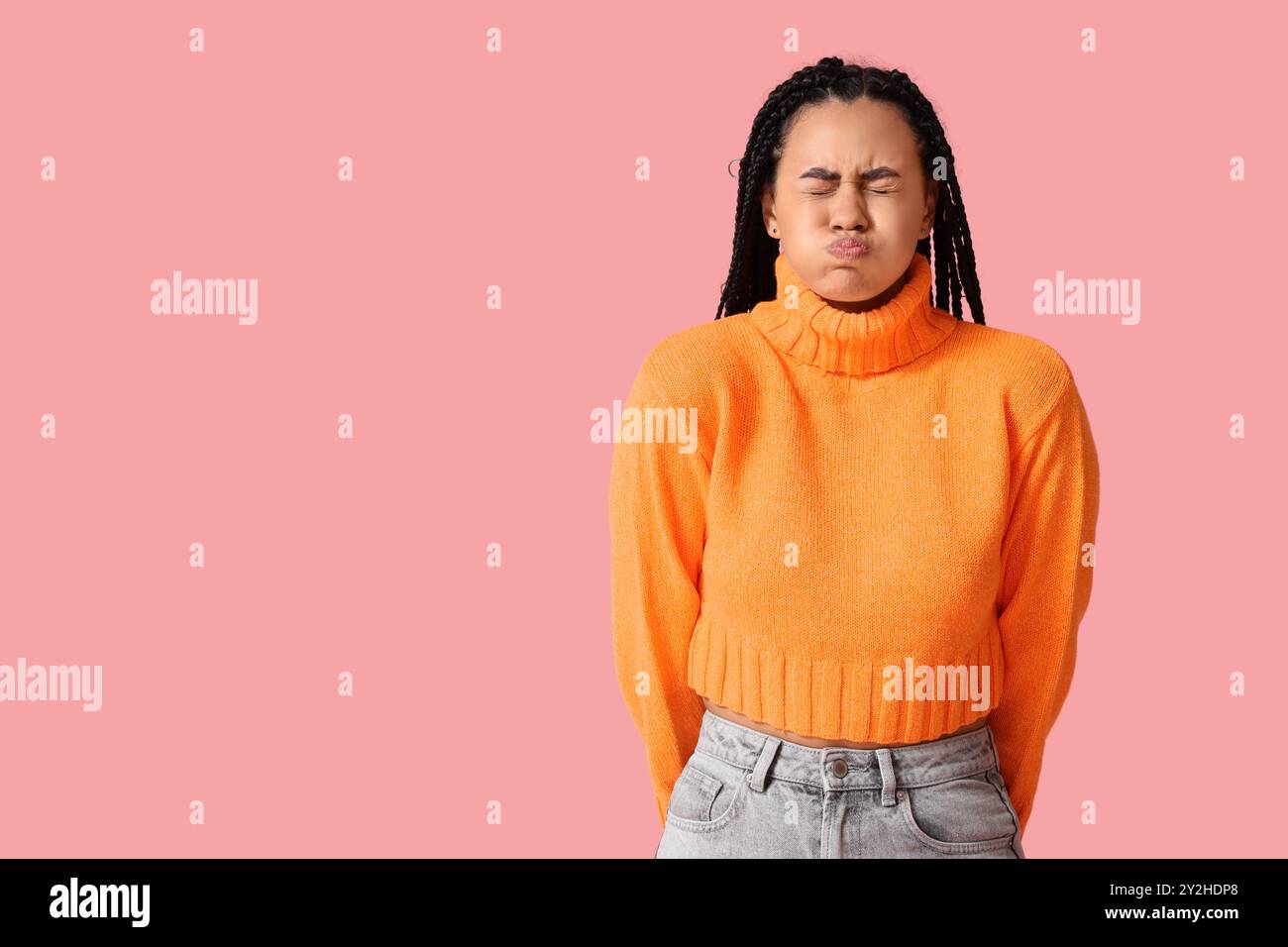 Beautiful young angry African-American woman blowing cheeks on pink ...