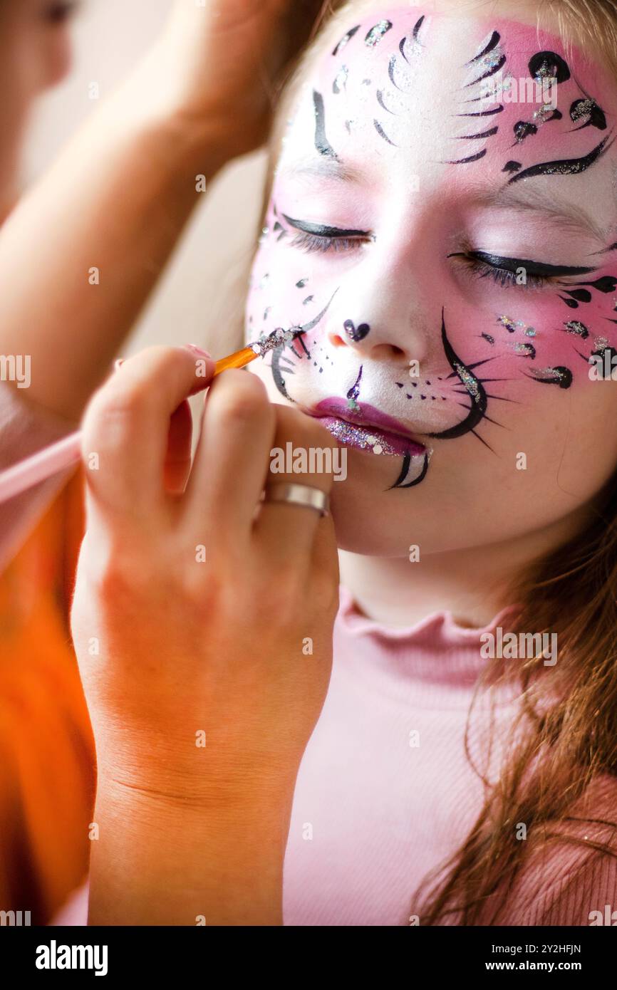 Cute makeup little tiger. girl getting face painting outdoors Stock ...