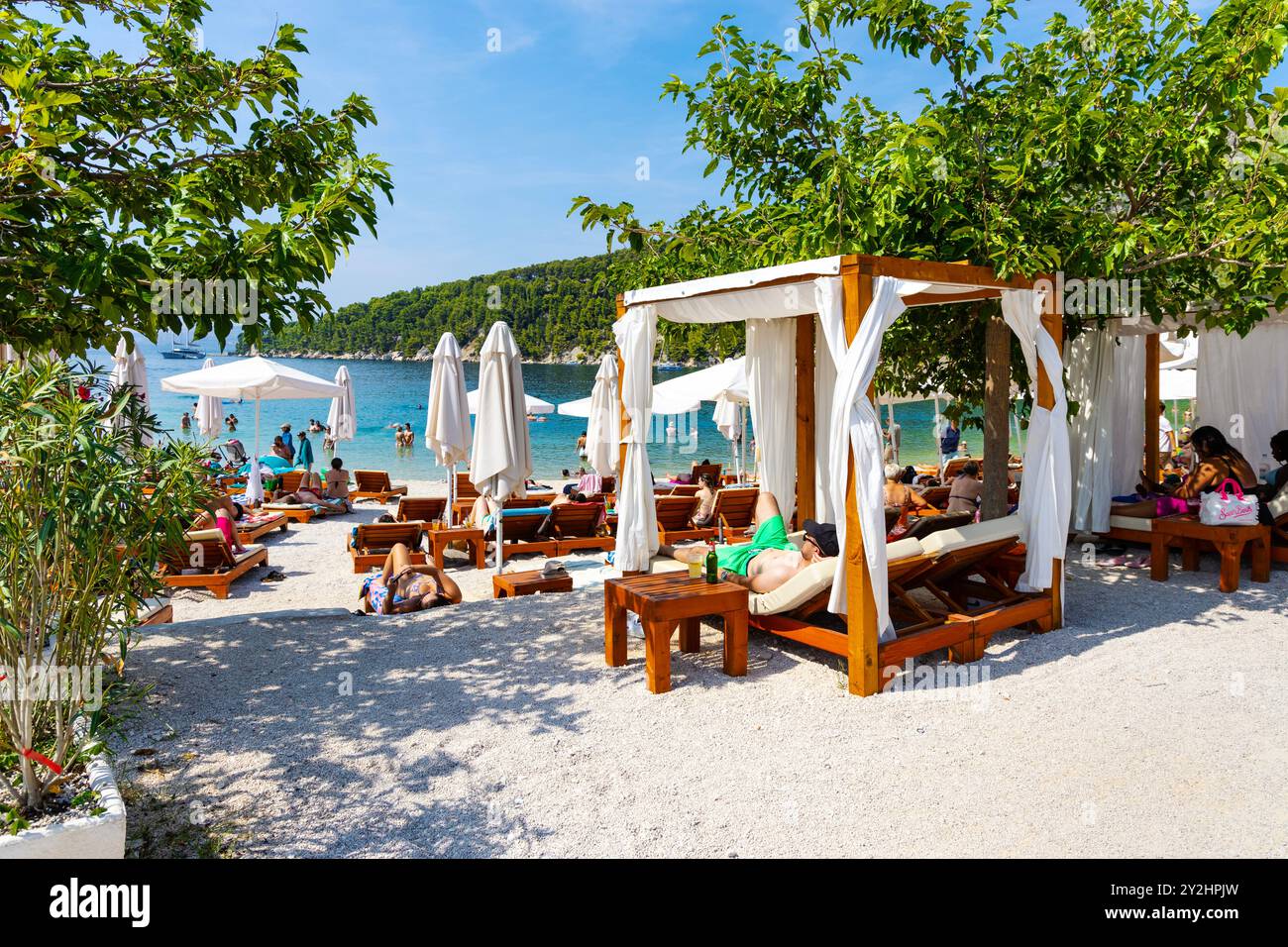 People relaxing in sun beds at Kasjuni Beach (Plaža Kašjuni), Forest ...