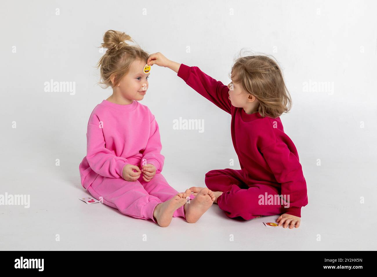 Two funny cute girls playing and having fun. Children with smiles and ...