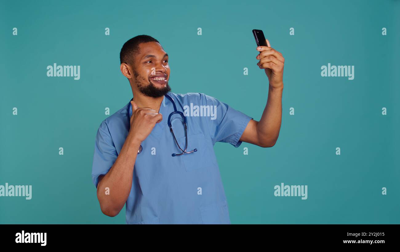 Male nurse using mobile phone to take selfies during hospital job shift ...