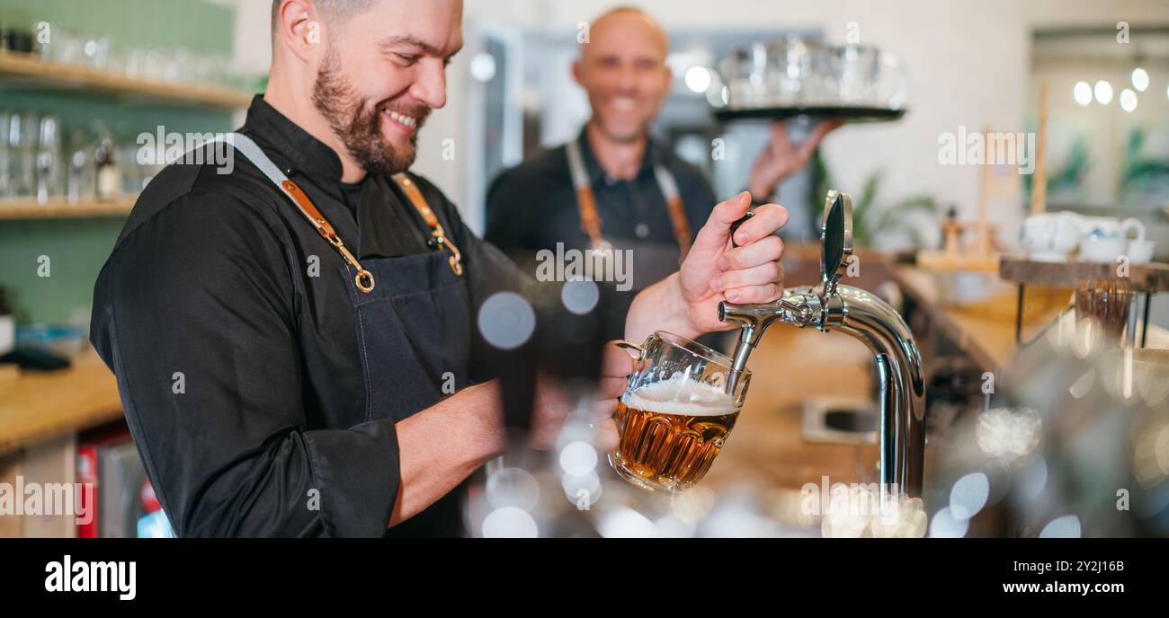 Stylish bearded barman dressed black uniform beer tapping at bar ...