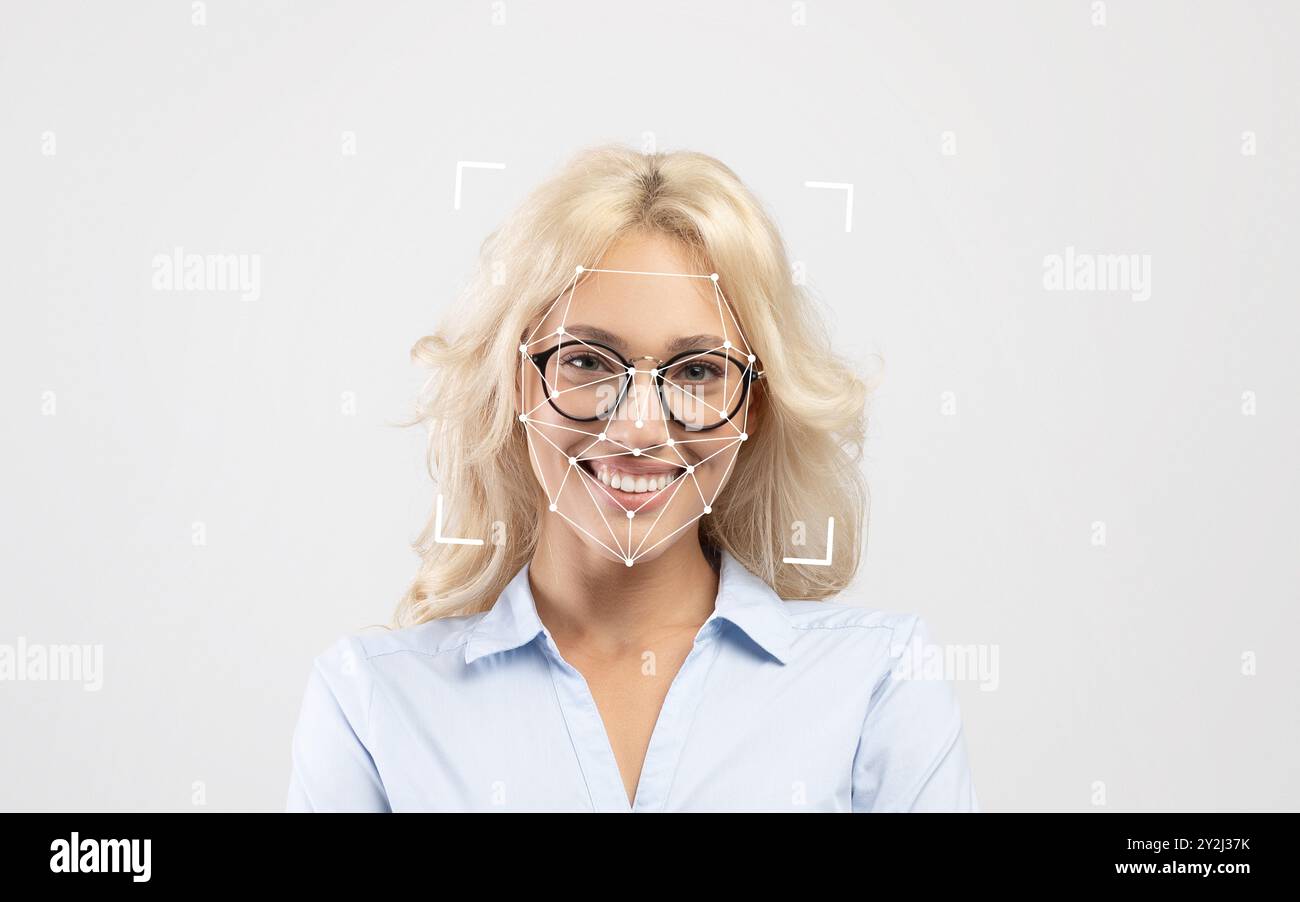 Young woman smiling with glasses and digital facial recognition overlay ...