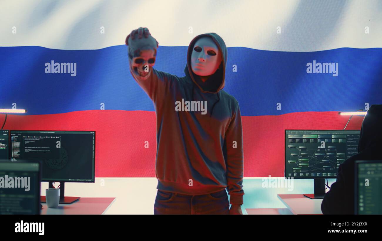 Russian cyber criminal with anonymous mask and hood holding a skull ...