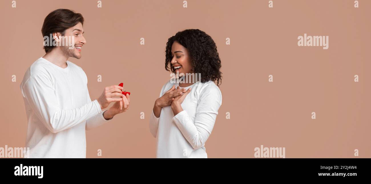 Romantic guy proposing to his surprised girlfriend, giving ring Stock ...